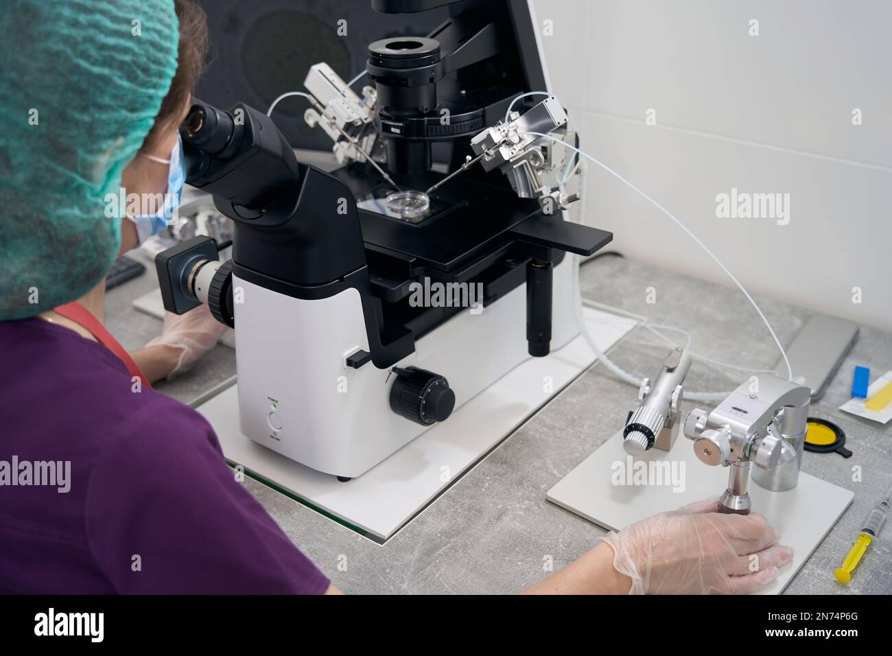 Doctor under microscope with micromanipulator carries out fertilization ...