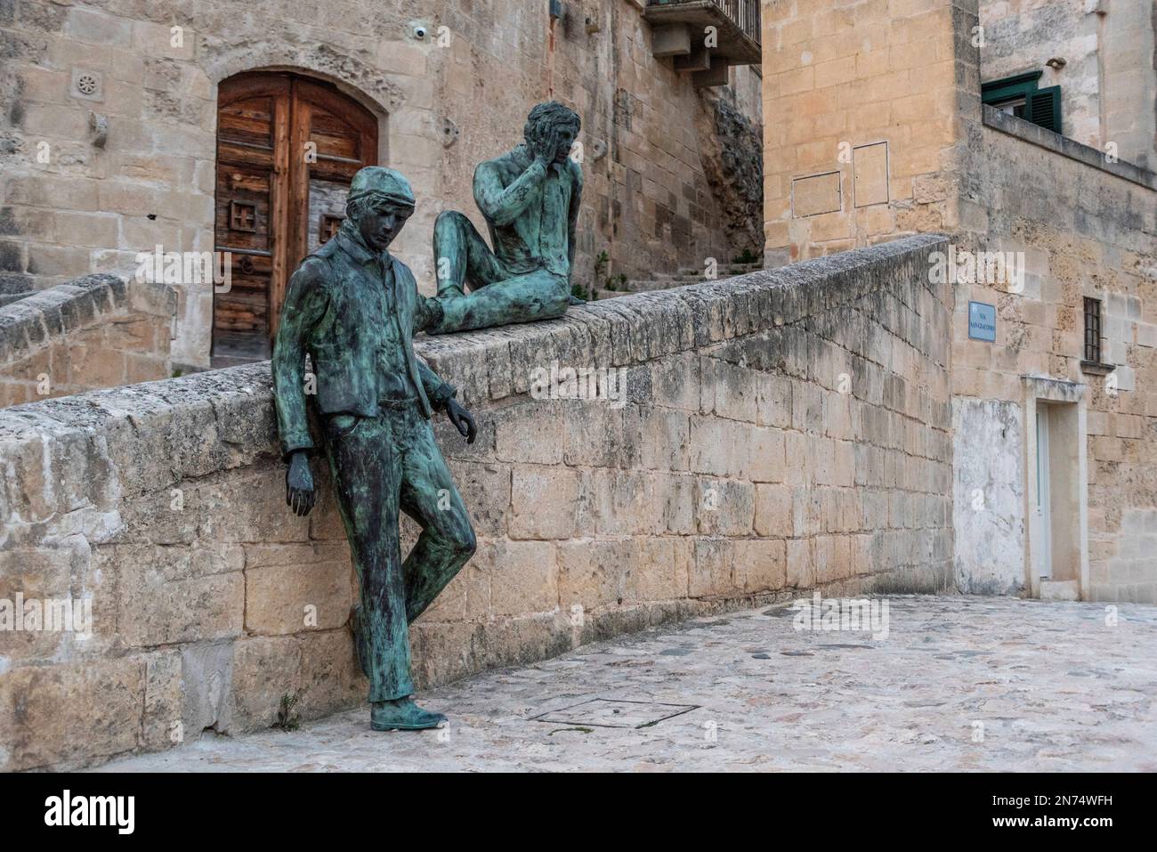 Artistic sculpture of people staying at a fountain in Sassi di Matera ...