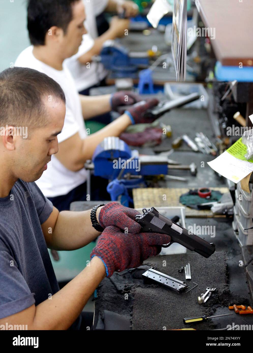 In this photo taken Wednesday July 17, 2013, workers at Armscor, the ...