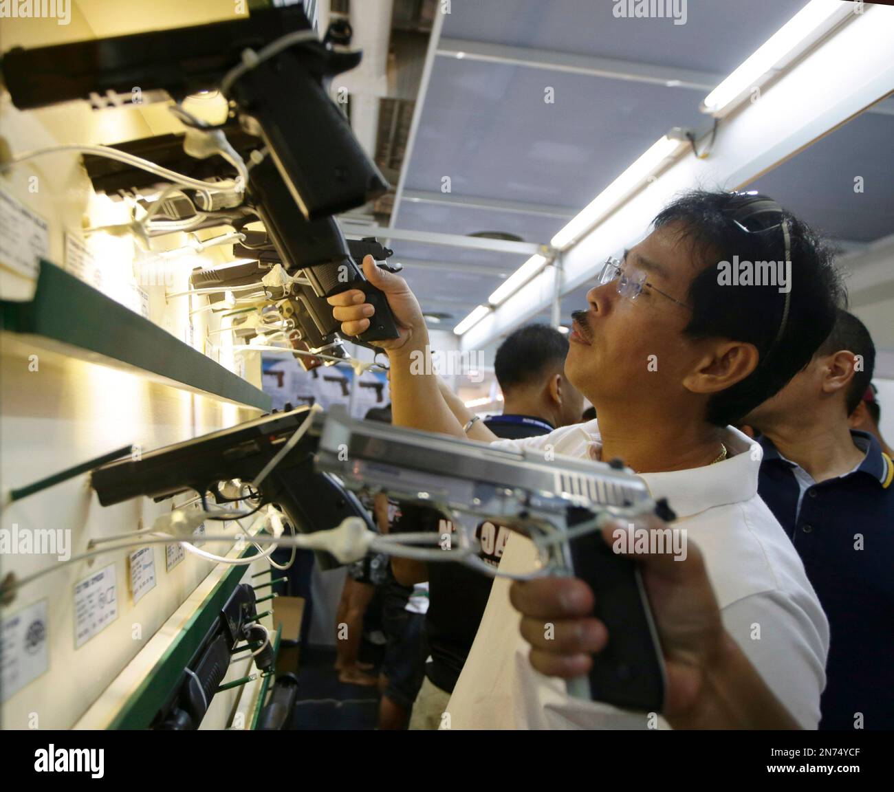 Filipino gun enthusiasts check out handguns on display at the 21st ...