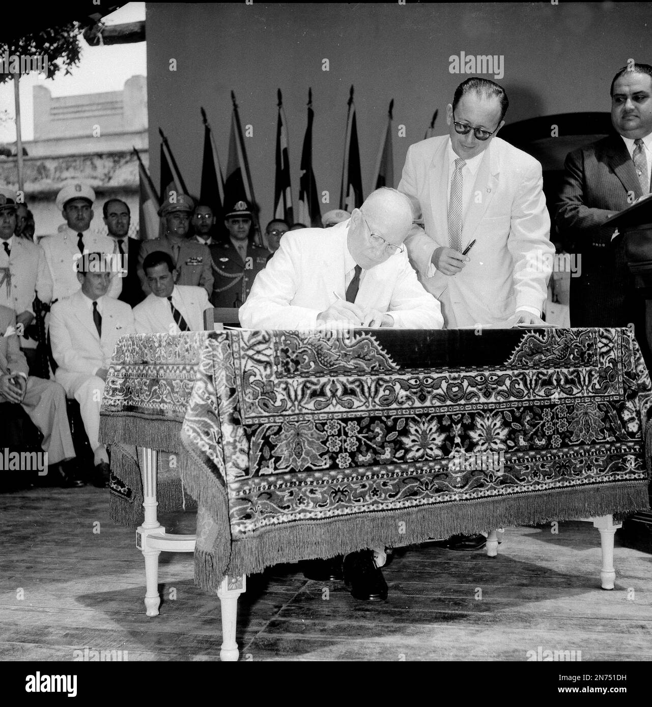 U.S. President Dwight D. Eisenhower puts his signature to the ...