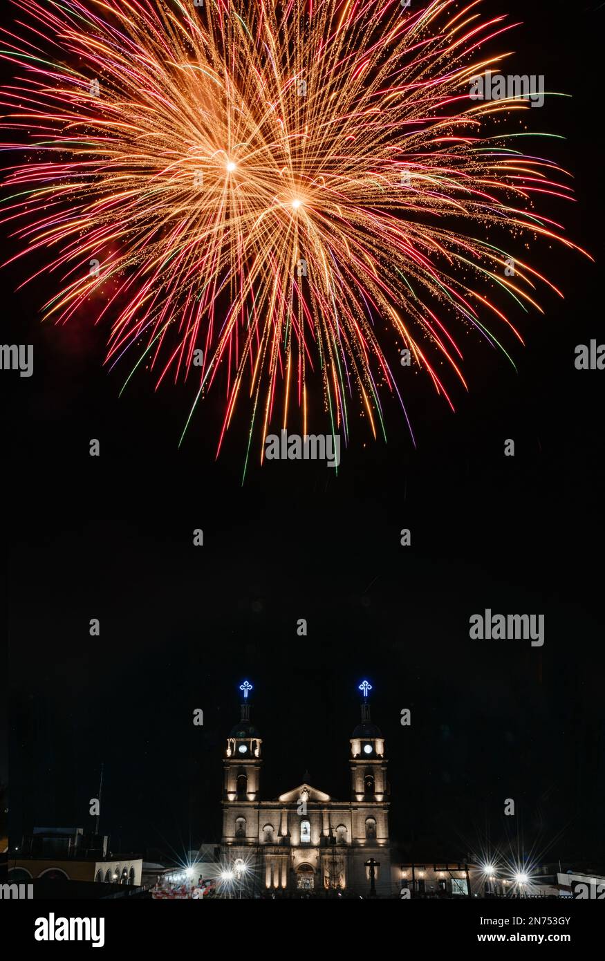 A Vertical shot of fireworks in front of church during city's holidays ...