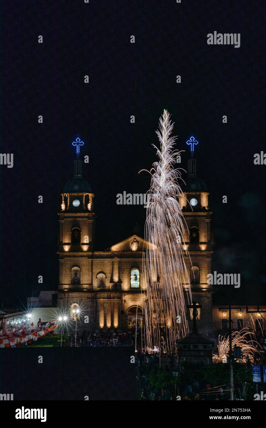 A Vertical shot of fireworks in front of church during city's holidays ...