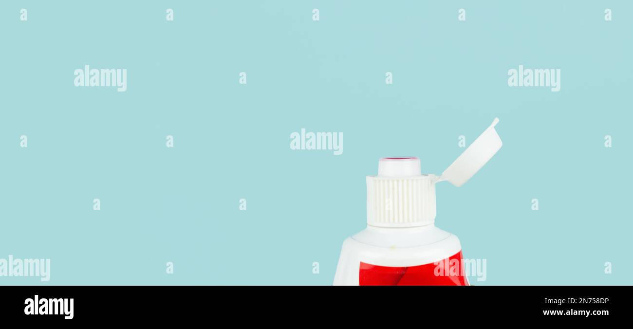 Small Red Toothpaste Tube with open lid on blue background. Means to ...