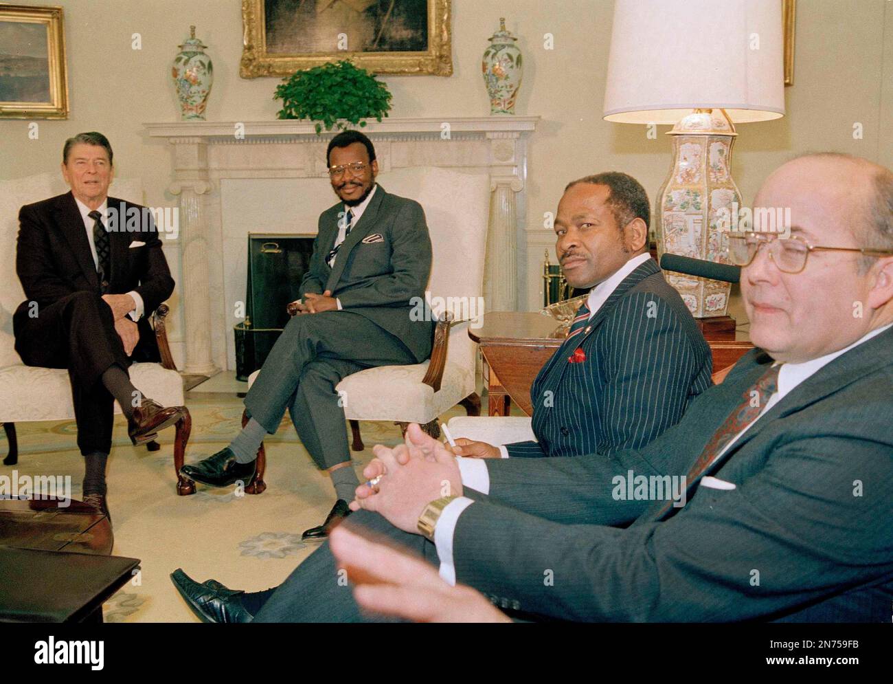 National Security Adviser Vice Adm. John Poindexter, seated at right ...