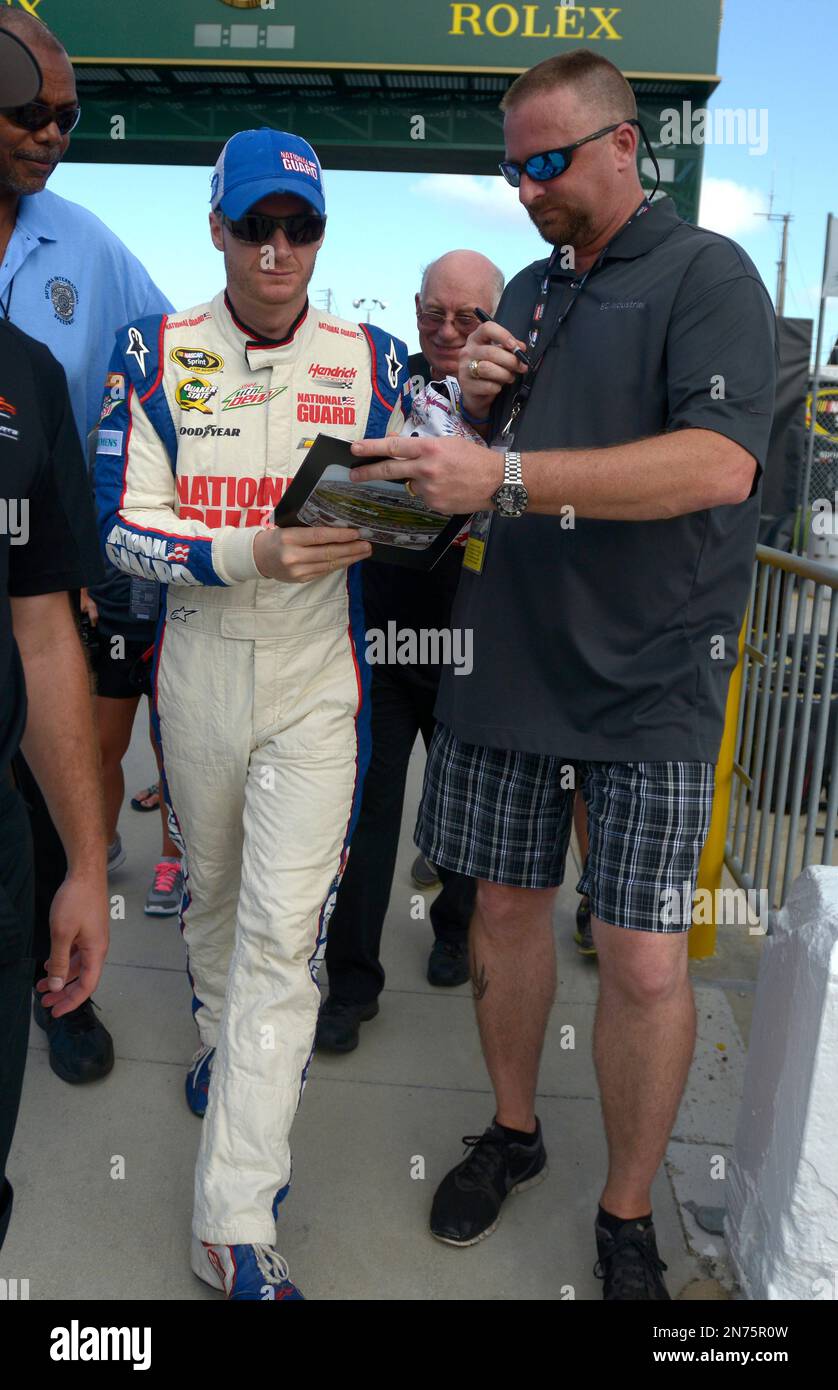 Dale Earnhardt Jr., left, signs an autograph on pit road during ...