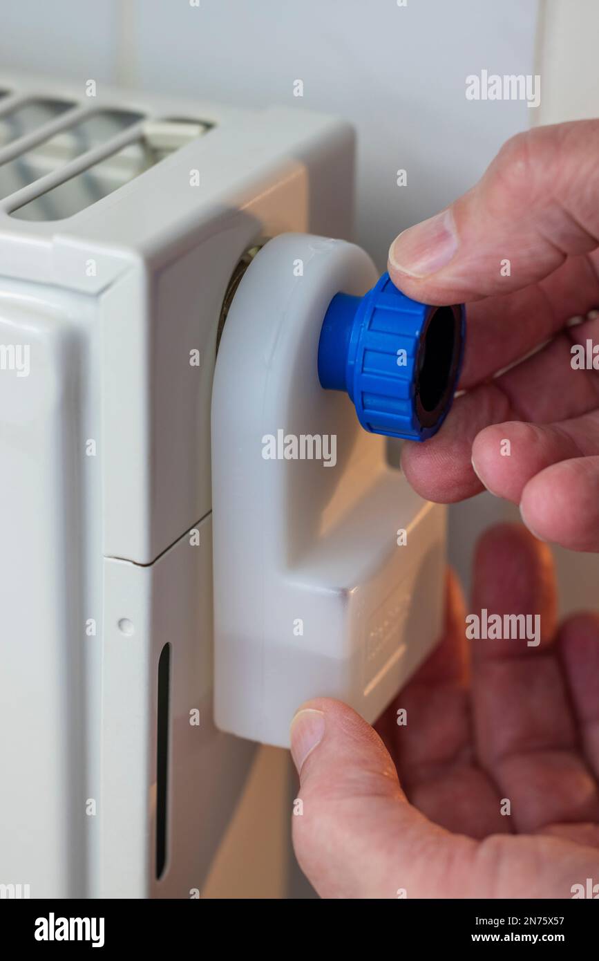 Man hand hold radiator vent tank with integrated vent key on the vent ...