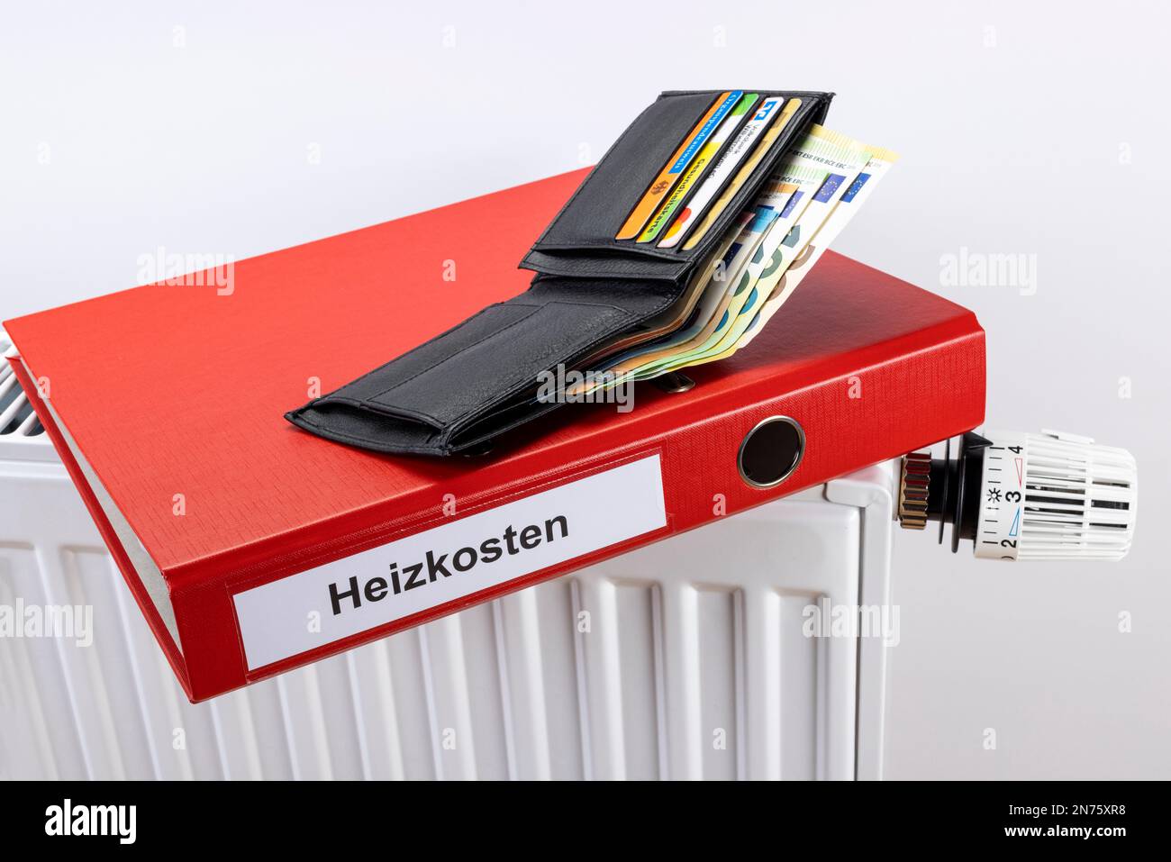 Black purse, red file folder with label energy costs, radiator ...