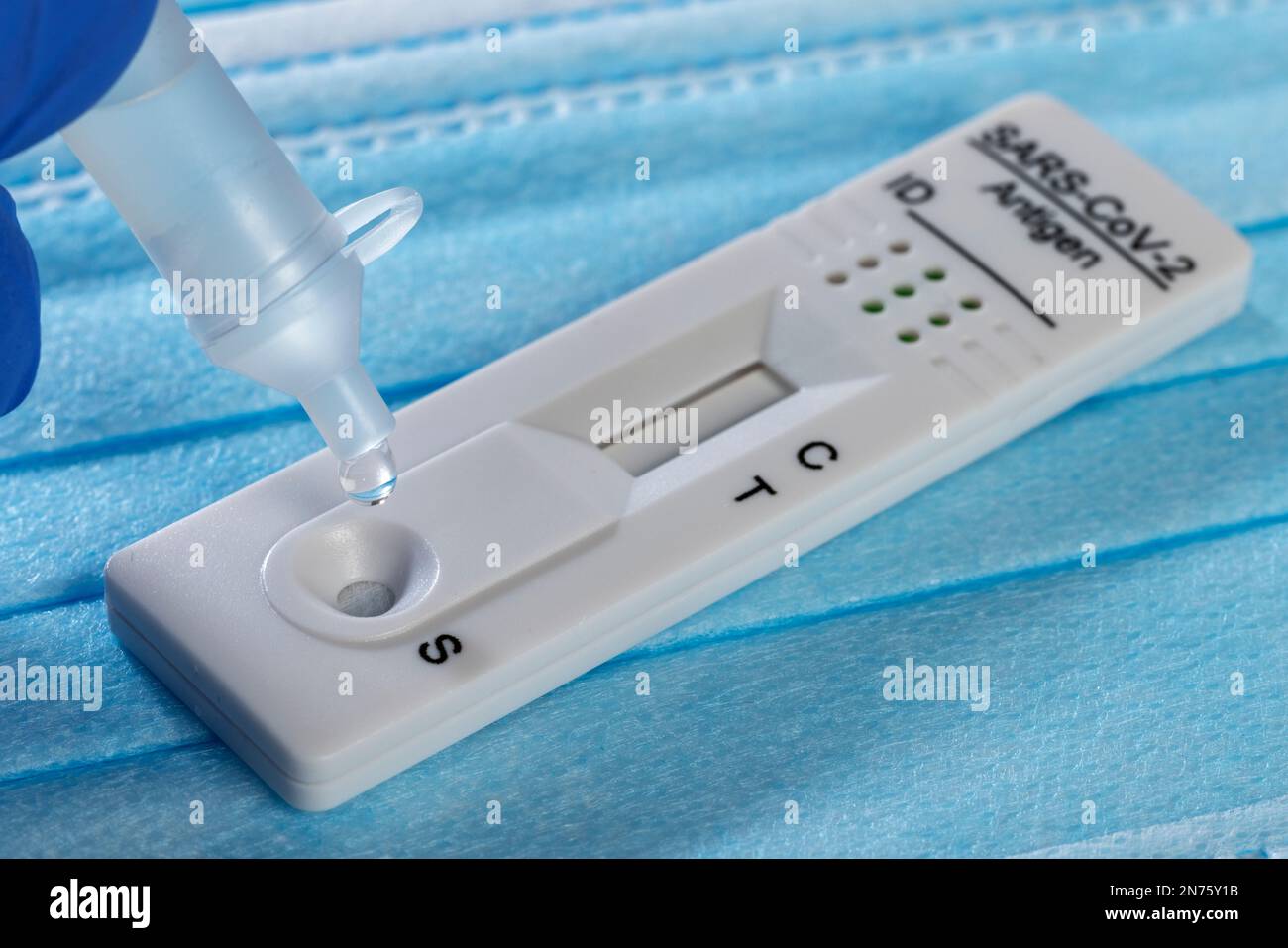 Put drops in sample well on the test cassette hi-res stock photography ...