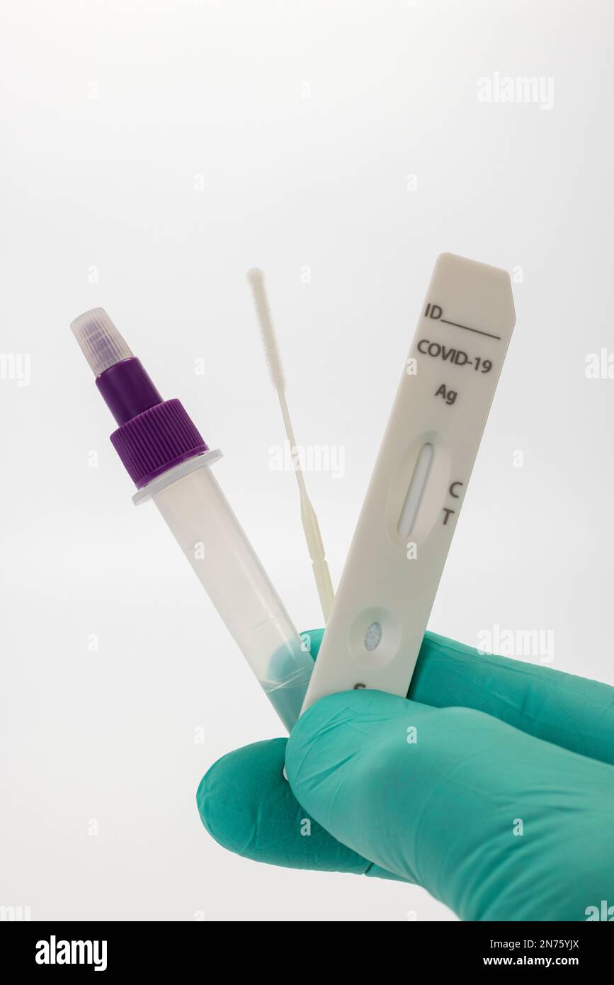 Male hand with green disposable medical glove holding new Covid-19 ...