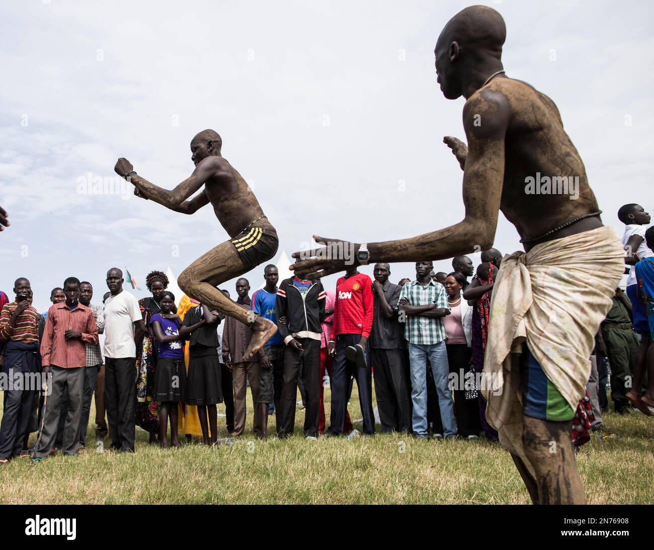 Dinka men covered in mud and cow dung perform a traditional dance at ...