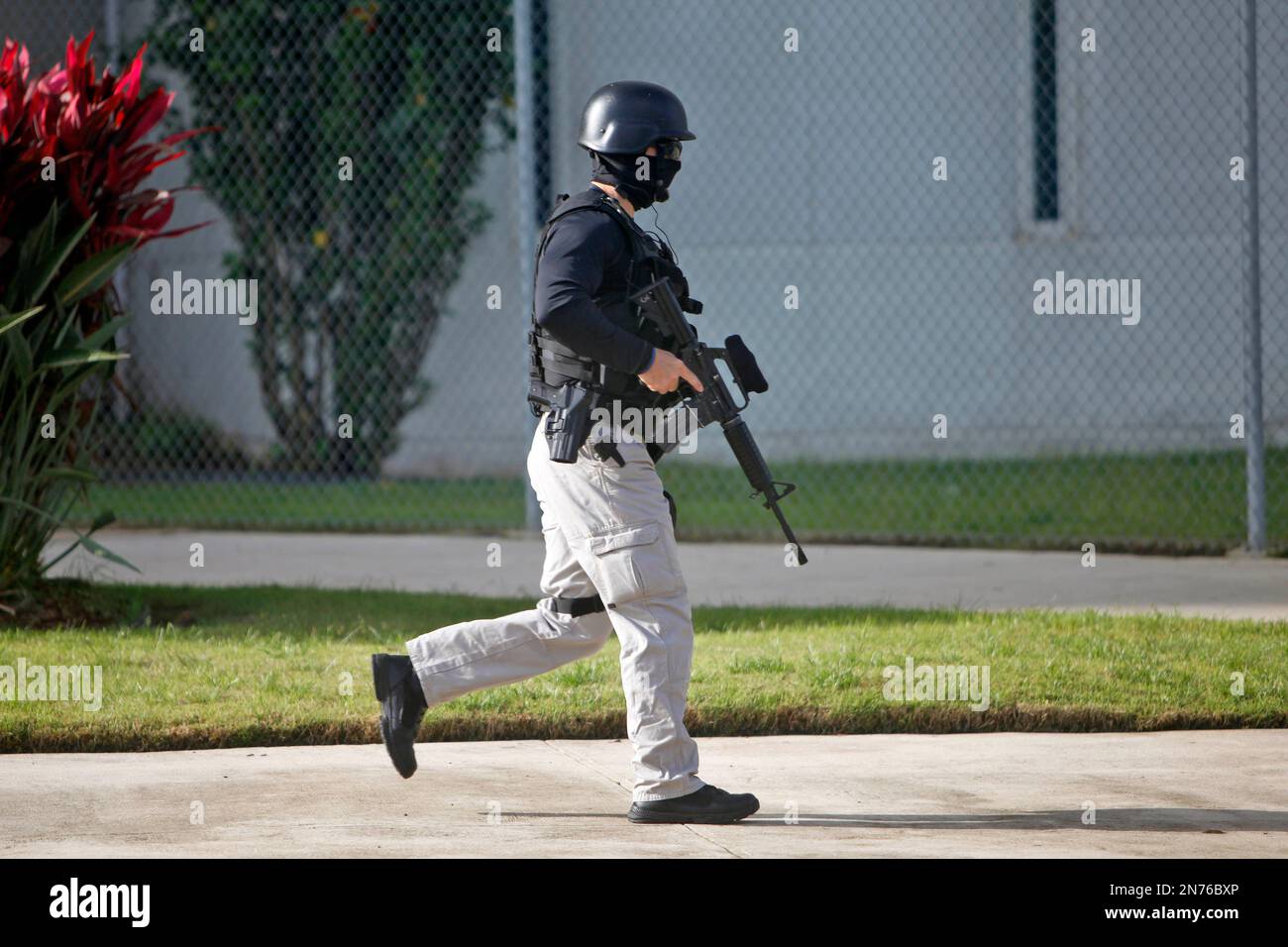 A federal police officer runs inside the prison as protestors sit in ...