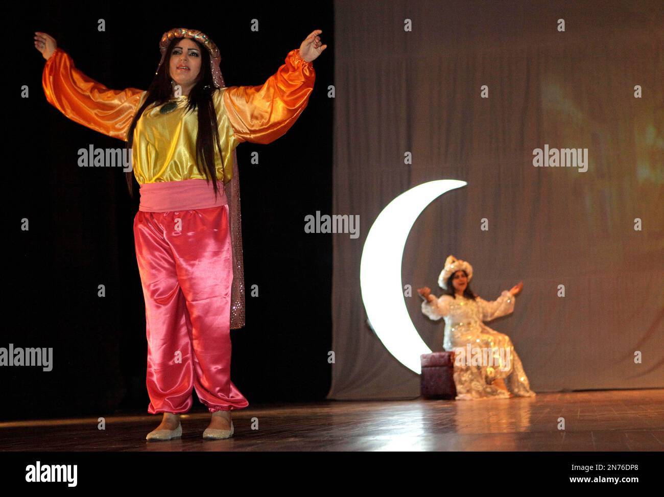 Dancers wearing traditional Iraqi folk costumes perform during a ...