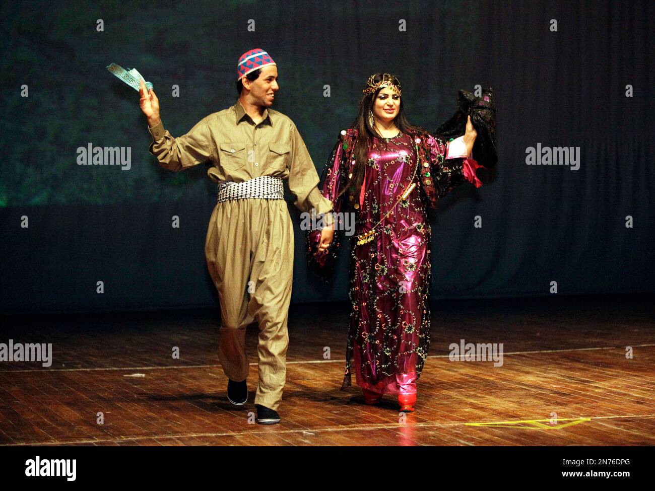 Dancers wearing traditional Iraqi folk costumes perform during a ...
