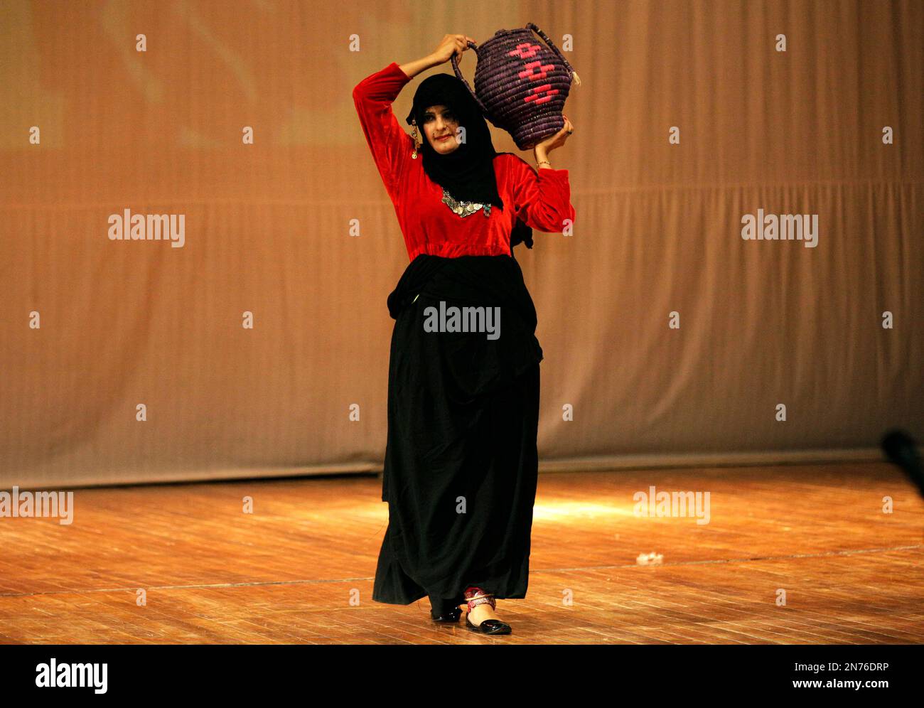 A dancer wearing a traditional Iraqi folk costume performs during a ...
