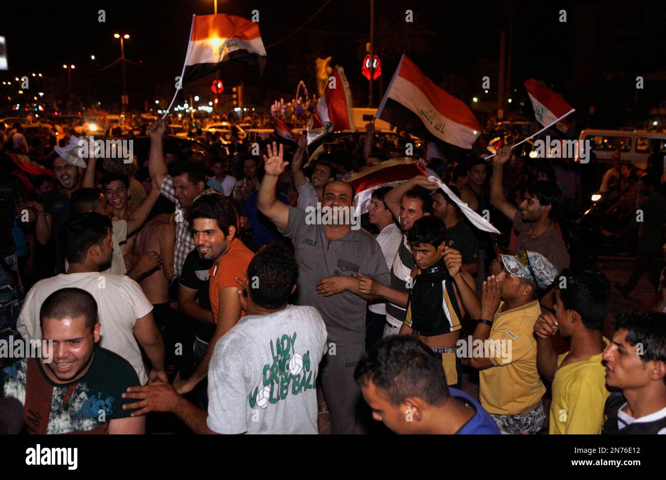 Iraqi soccer fans wave national flags as they celebrate after the Iraqi ...