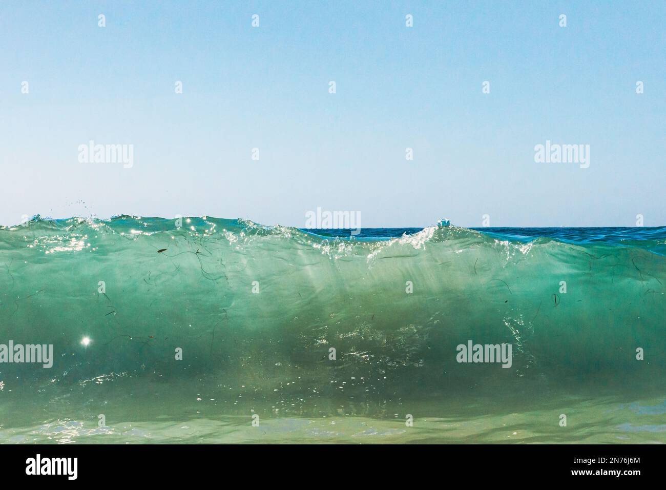 Low angle view of a wave with sunlight cutting through the water Stock ...