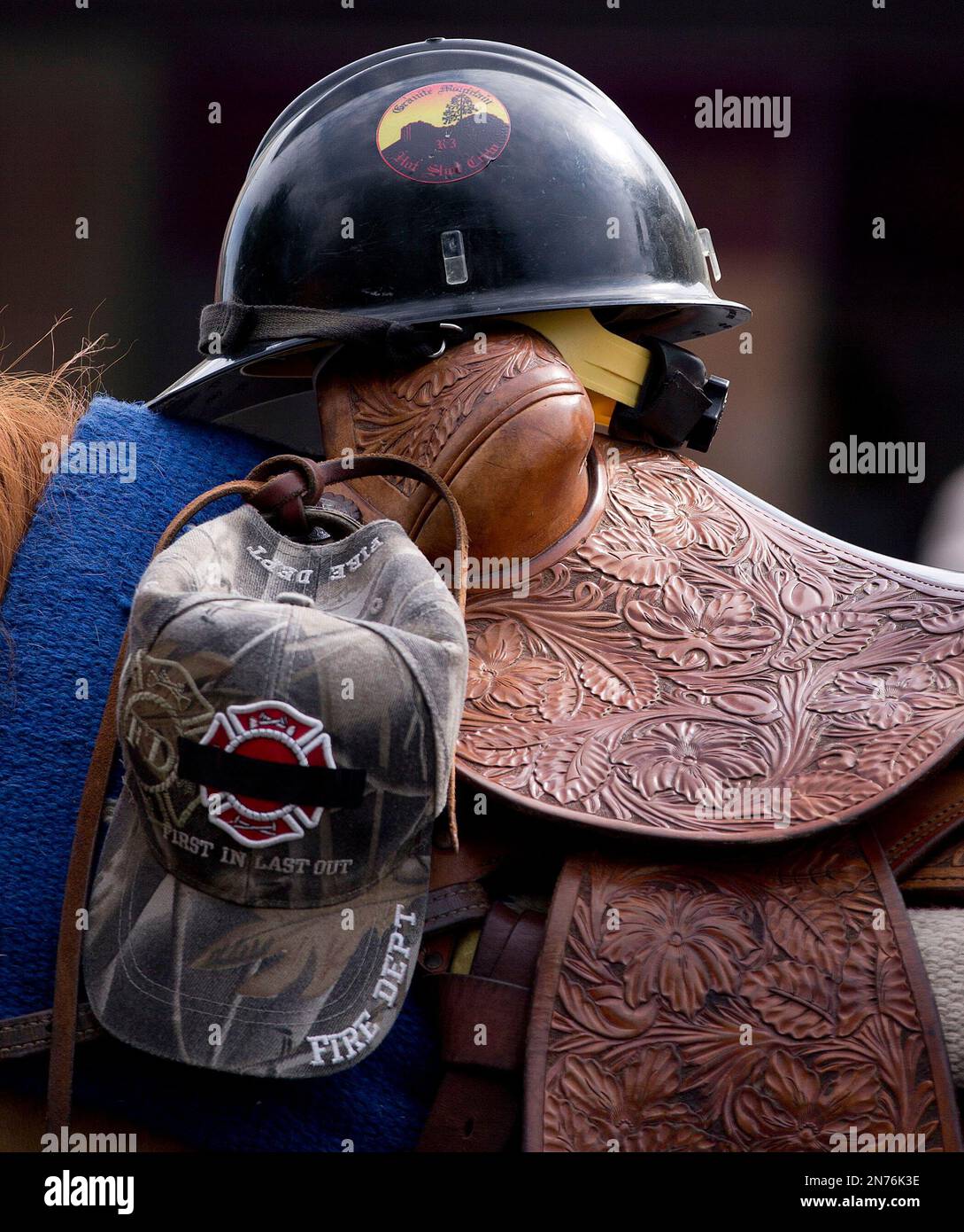 A firefighter's helmet sits atop a saddle of a riderless horse during ...