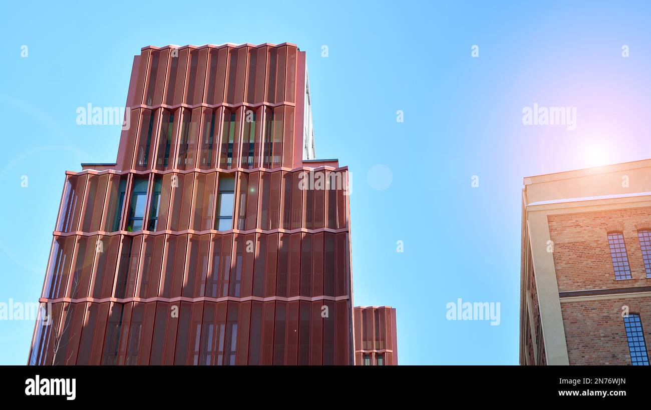 Revitalized red brick building and modern office building. Rising sun ...
