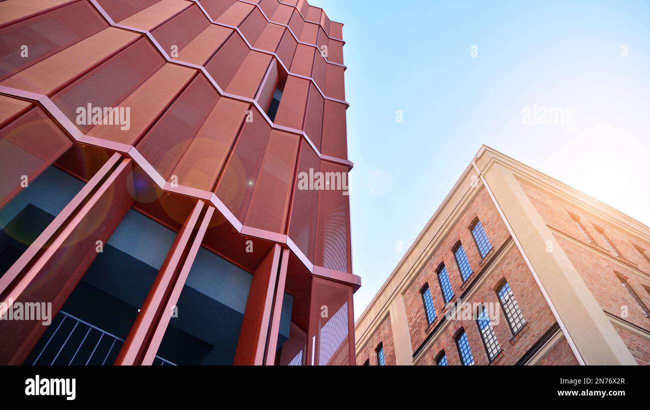 Revitalized red brick building and modern office building. Rising sun ...