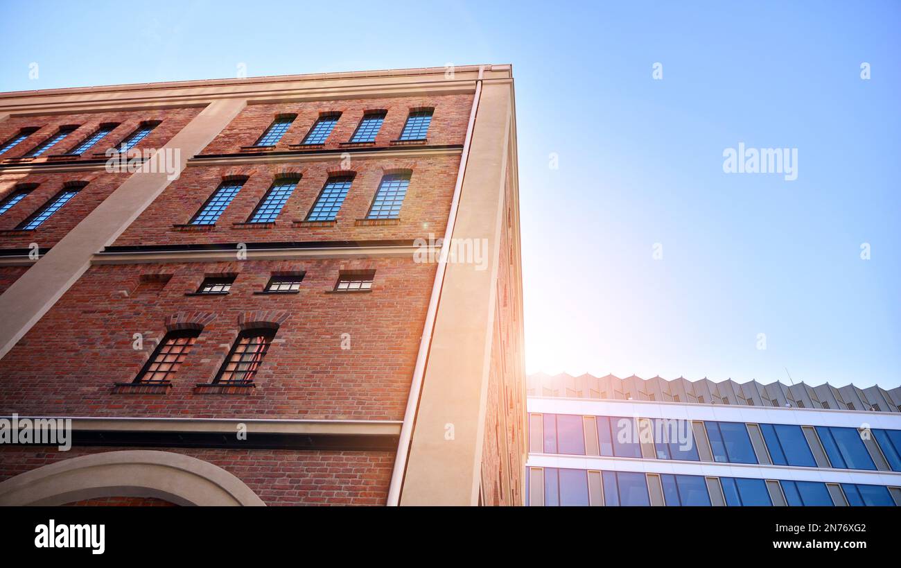 Revitalized red brick building and modern office building. Rising sun ...