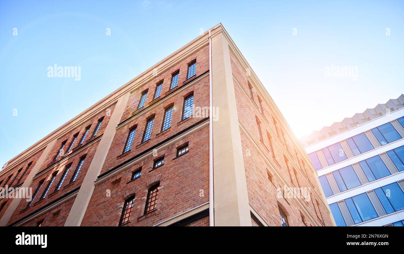 Revitalized red brick building and modern office building. Rising sun ...