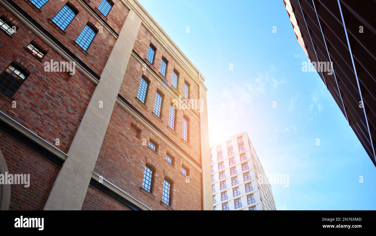 Revitalized red brick building and modern office building. Rising sun ...