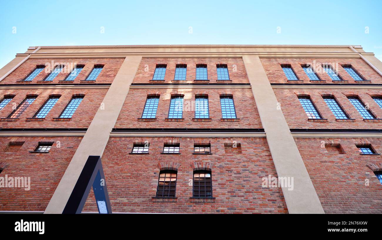 Revitalized red brick building and modern office building. Rising sun ...