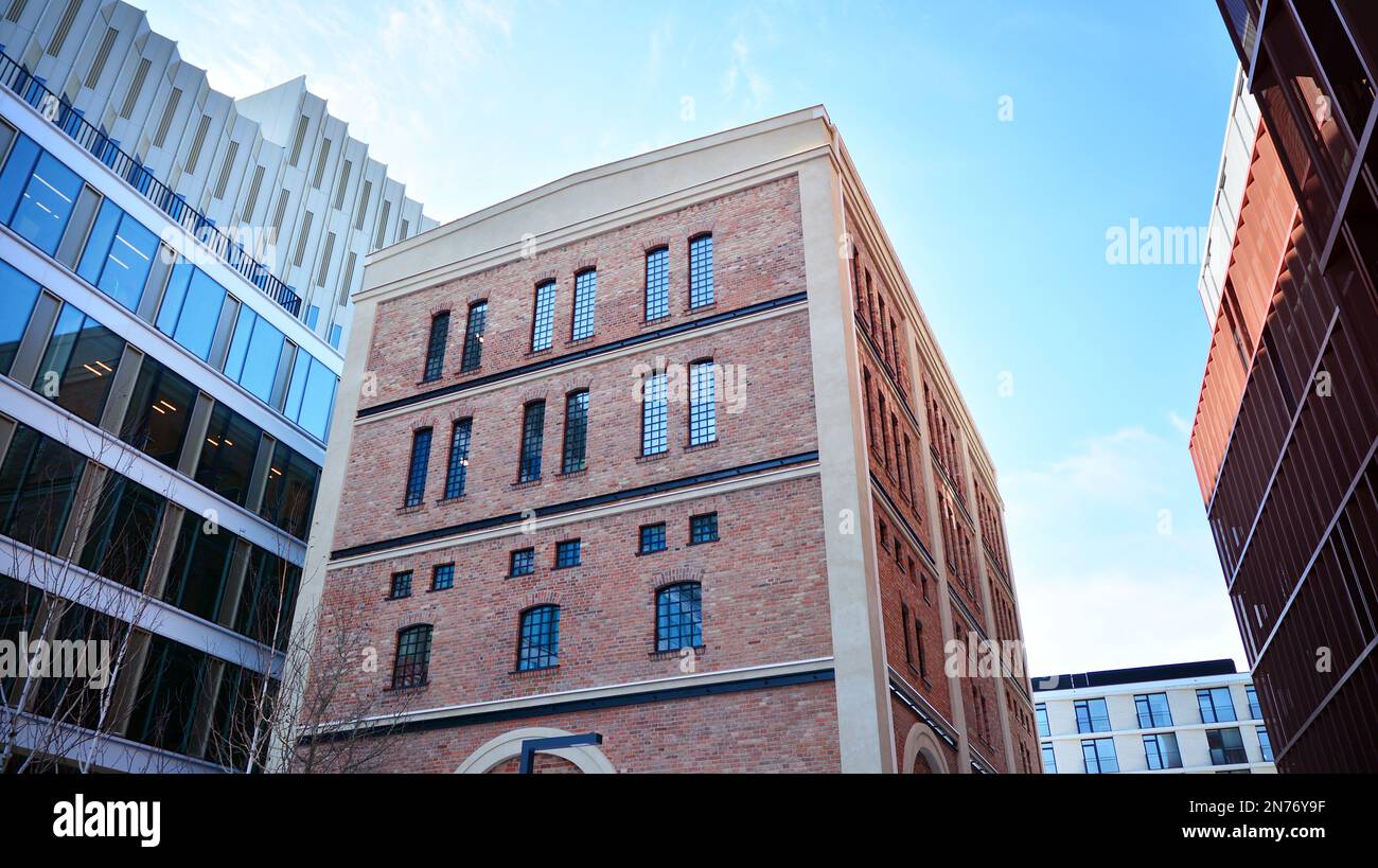 Revitalized red brick building and modern office building. Rising sun ...