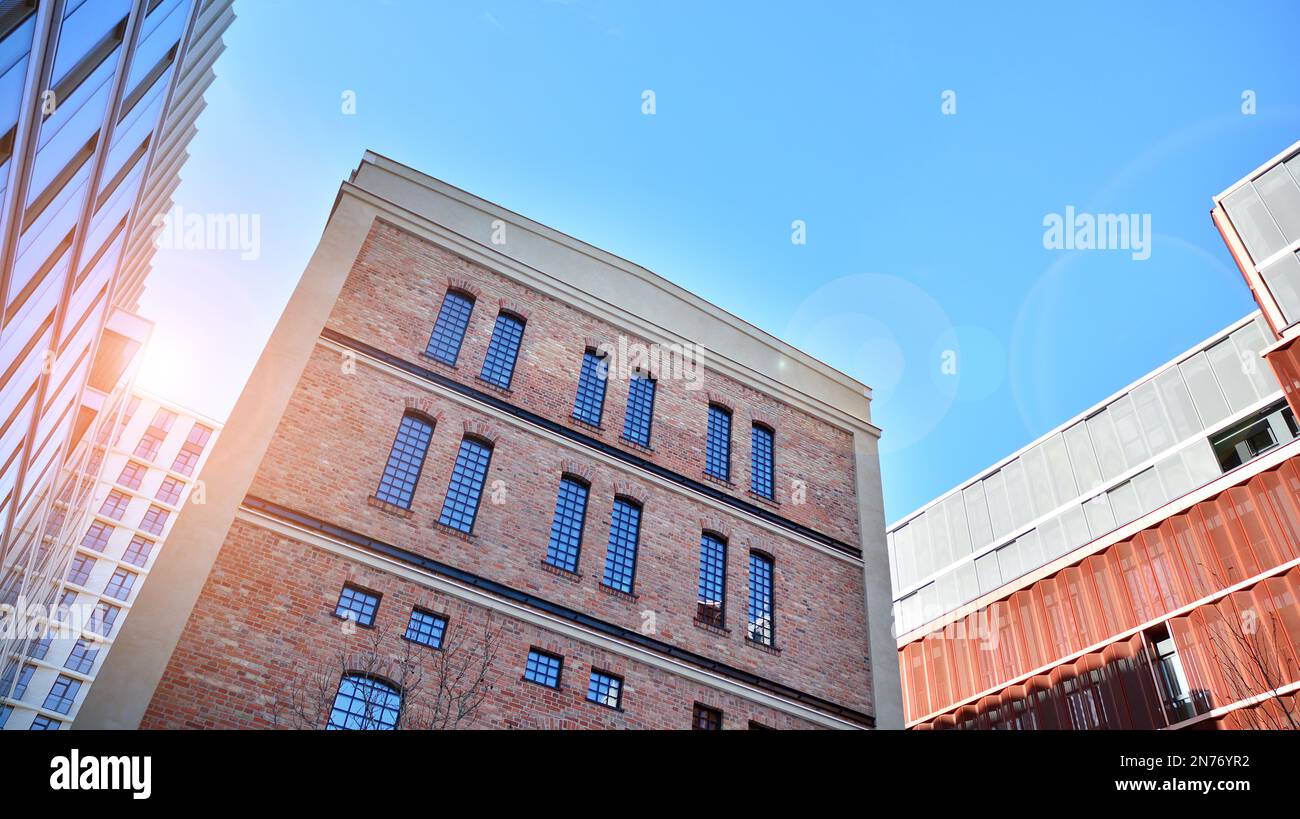 Revitalized red brick building and modern office building. Rising sun ...