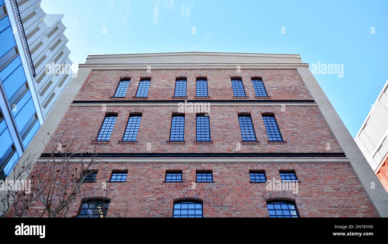 Revitalized red brick building and modern office building. Rising sun ...