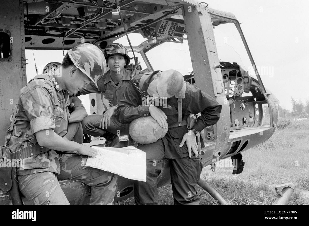 Capt. Tran Ngoc Hue, left, and Marine Captain Roger V. Wellbrook go over a map before starting ...