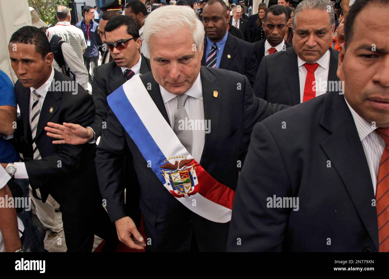 Panama's President Ricardo Martinelli is surrounded by security as he ...