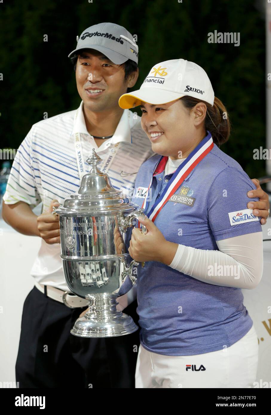 Inbee Park, right, poses for picture with her trophy and her caddy ...