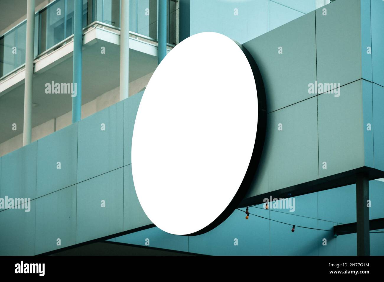 Empty white circle mockup signboard template on modern building wall ...