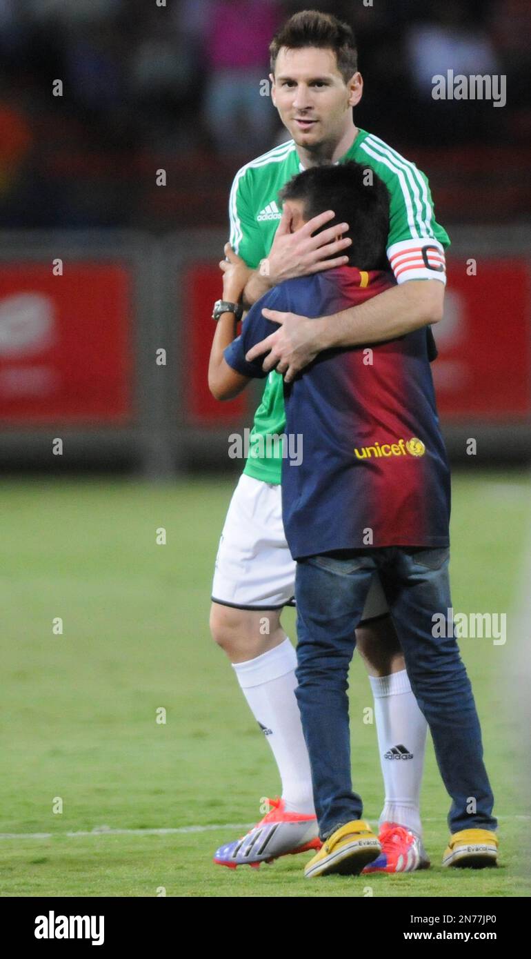 A boy embraces Argentina's Lionel Messi at the end of an exhibition ...