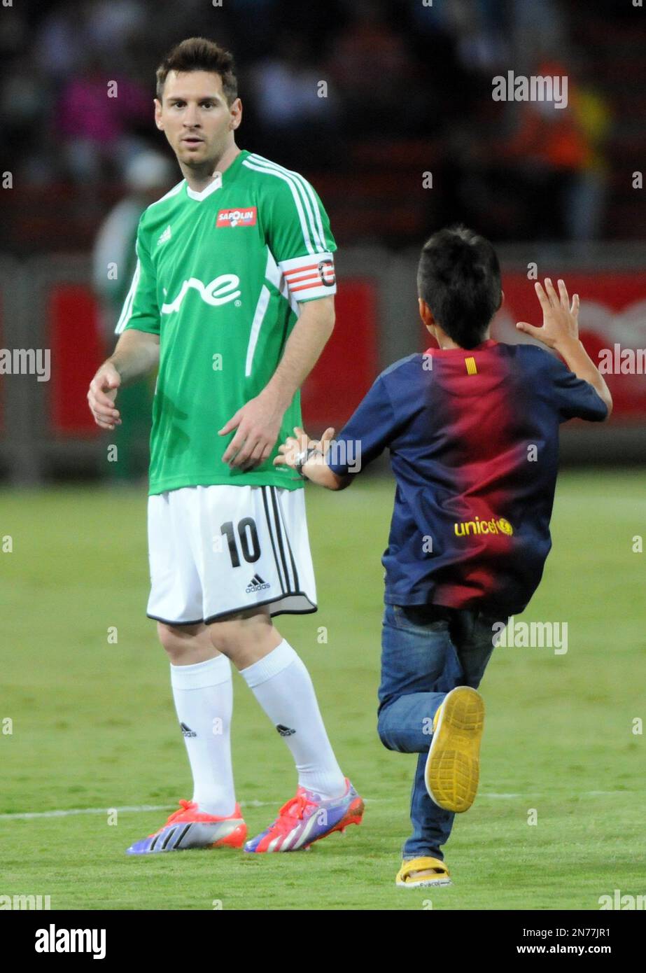 A boy runs toward Argentina's Lionel Messi at the end of an exhibition ...