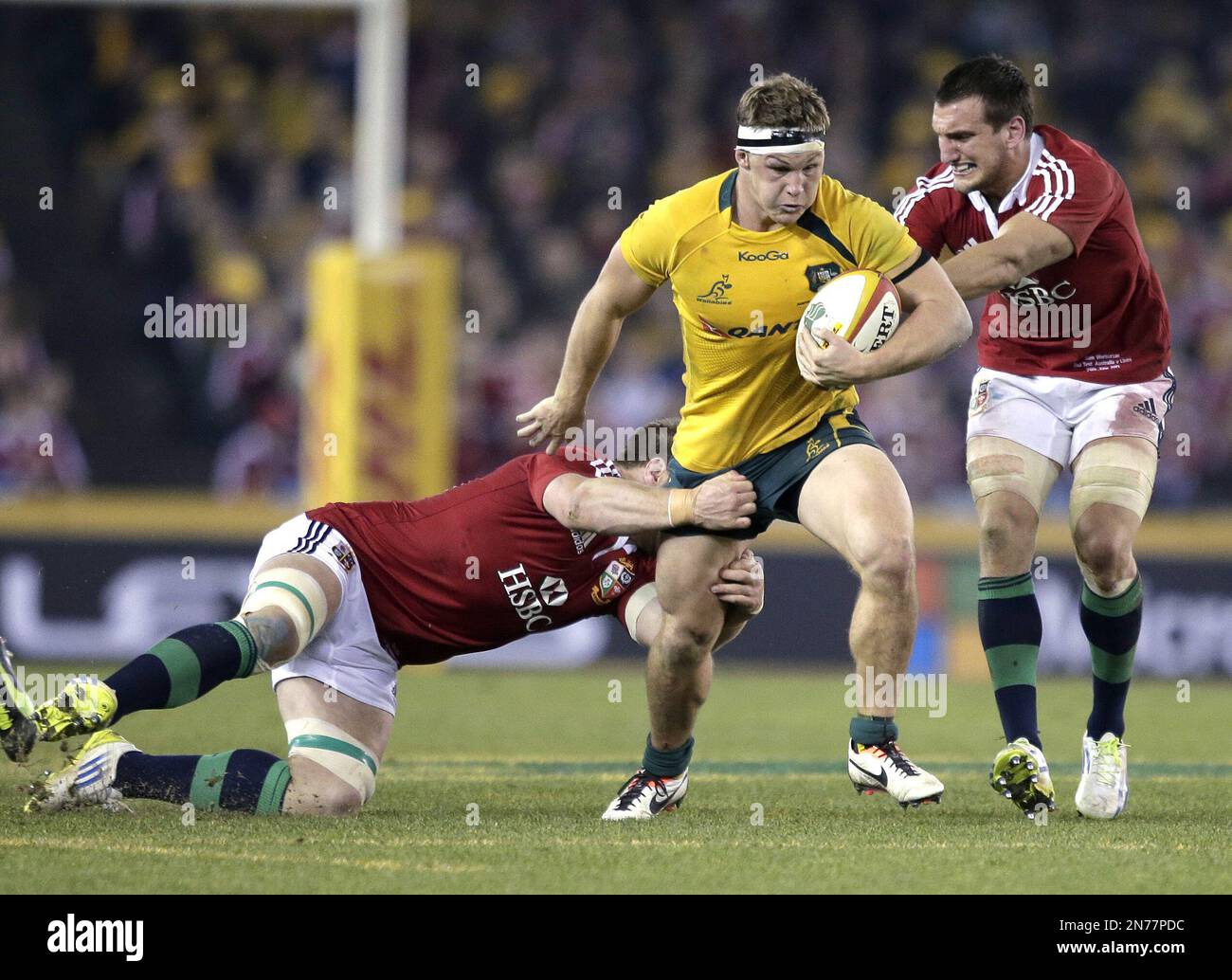 Australia's Michael Hooper, center, breaks the tackles from British and ...