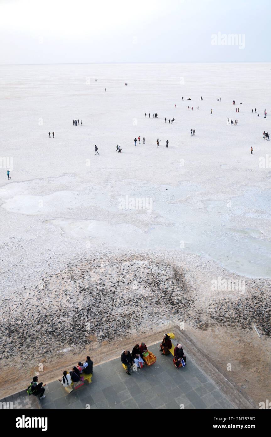 A vertical aerial shot of the desert with white salt full of tourists ...