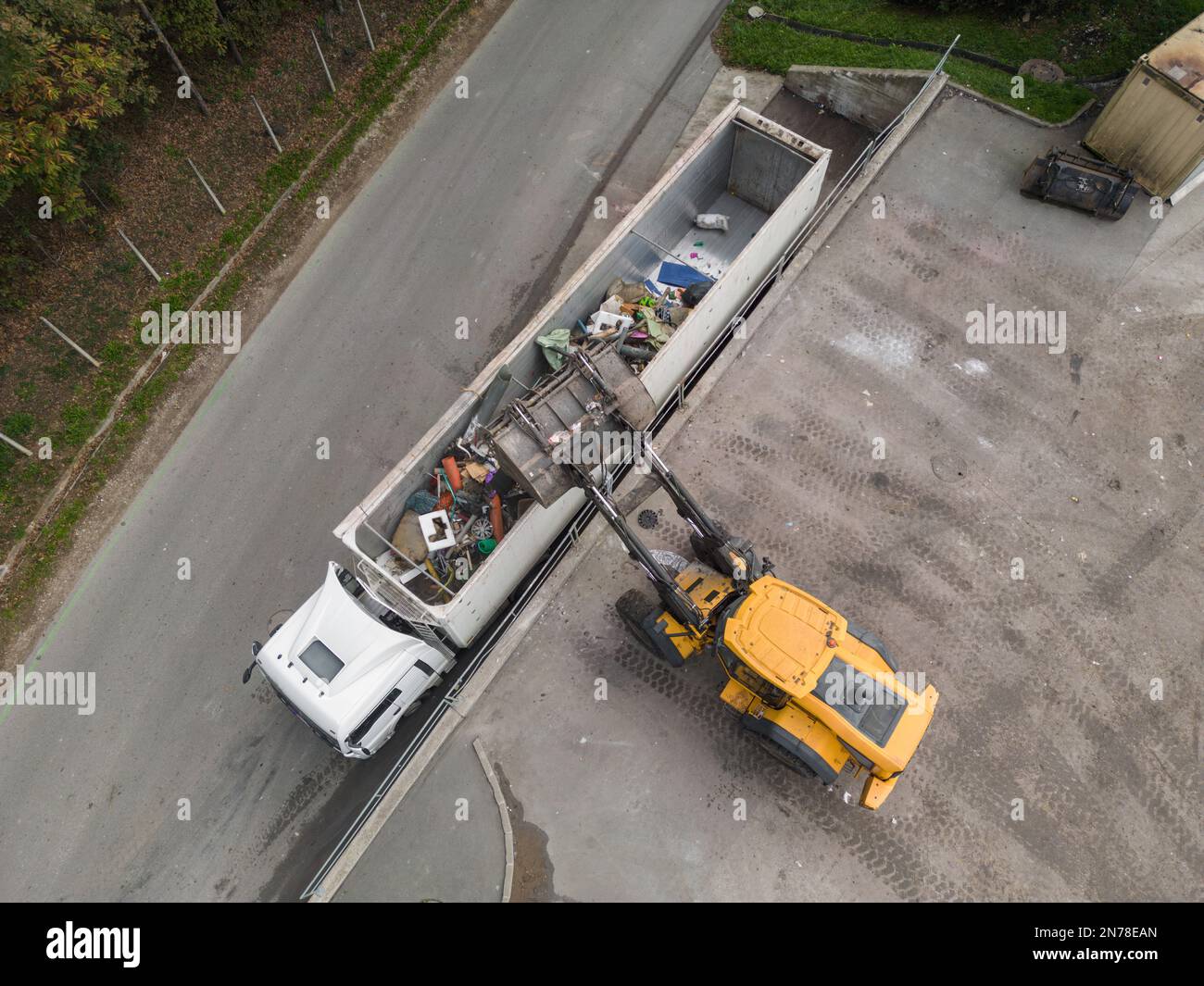Waste loading operation, loader dumping trash in a truck on a site for ...