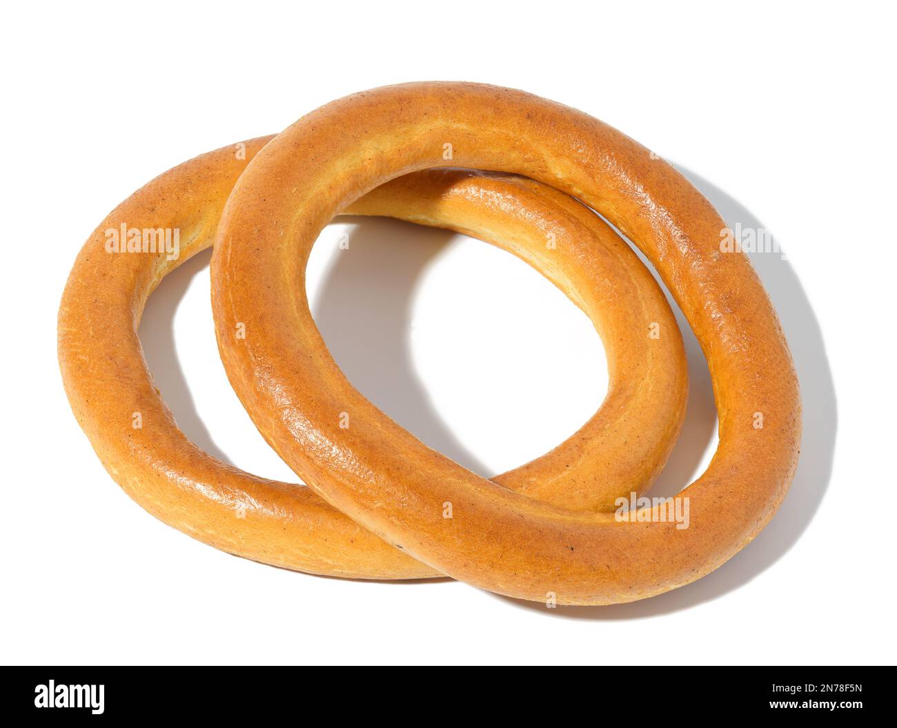 Baked round bagel made of white wheat flour on a white isolated ...