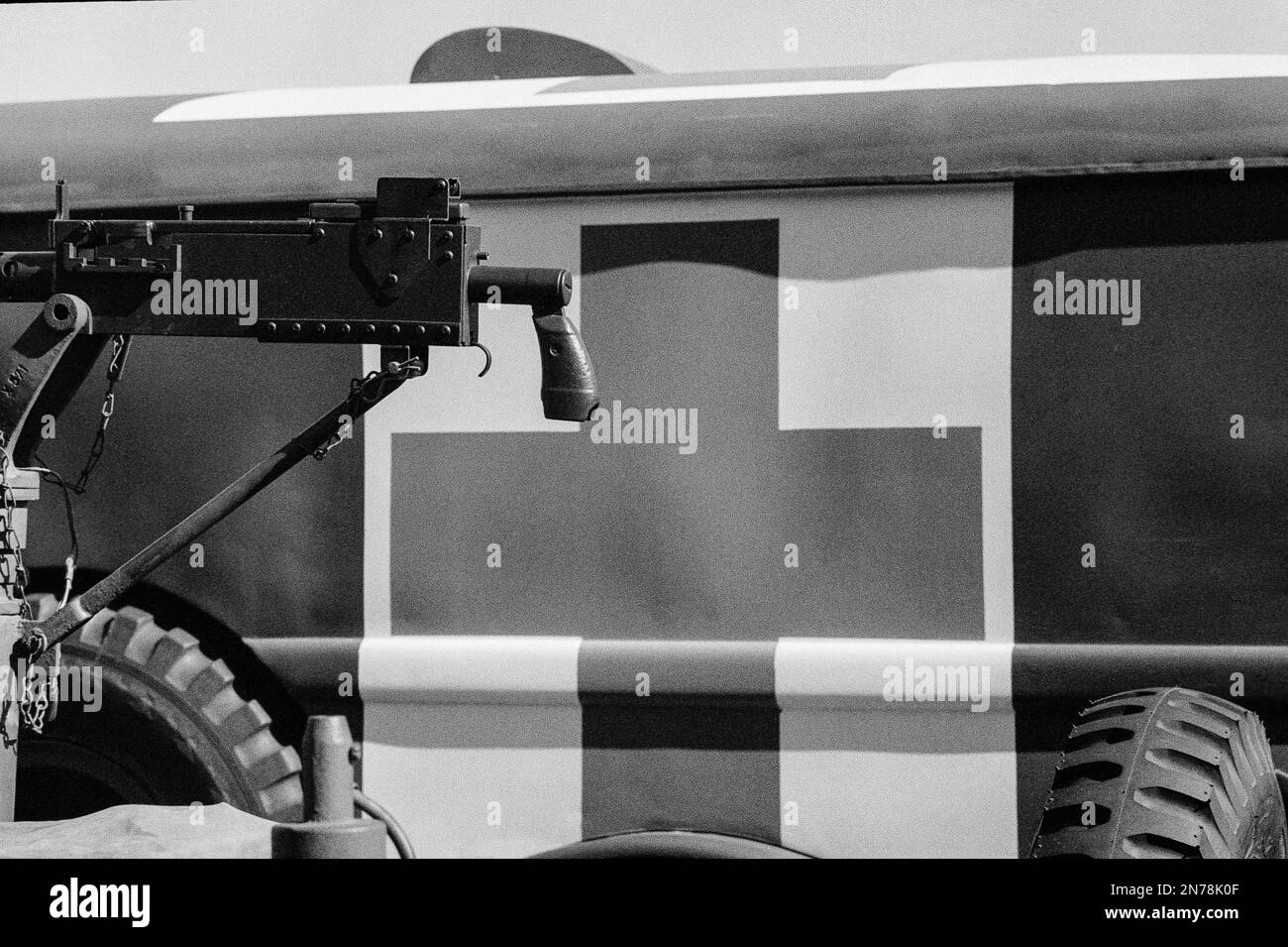 A truck displaying a large Red Cross is visible behind a machine gun ...
