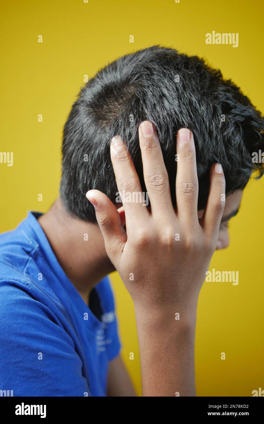 teenage boy Scratching Head Against black background Stock Photo - Alamy