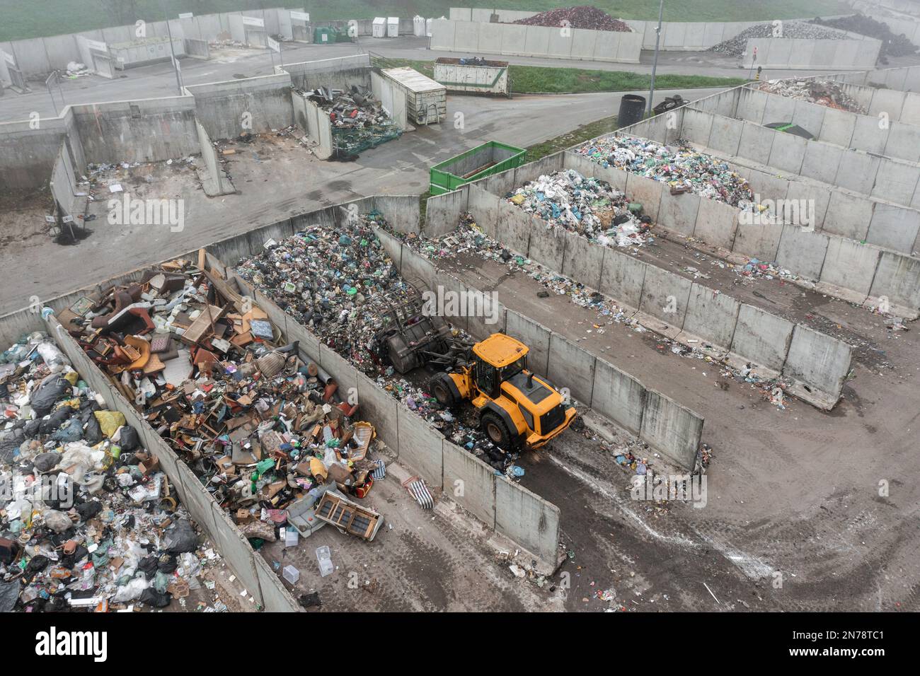 Skid steer loader moving garbage at the landfill site, before ...