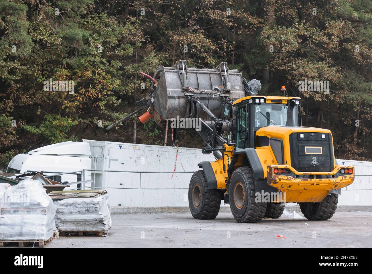 Waste loading operation, loader dumping trash in a truck on a site for ...