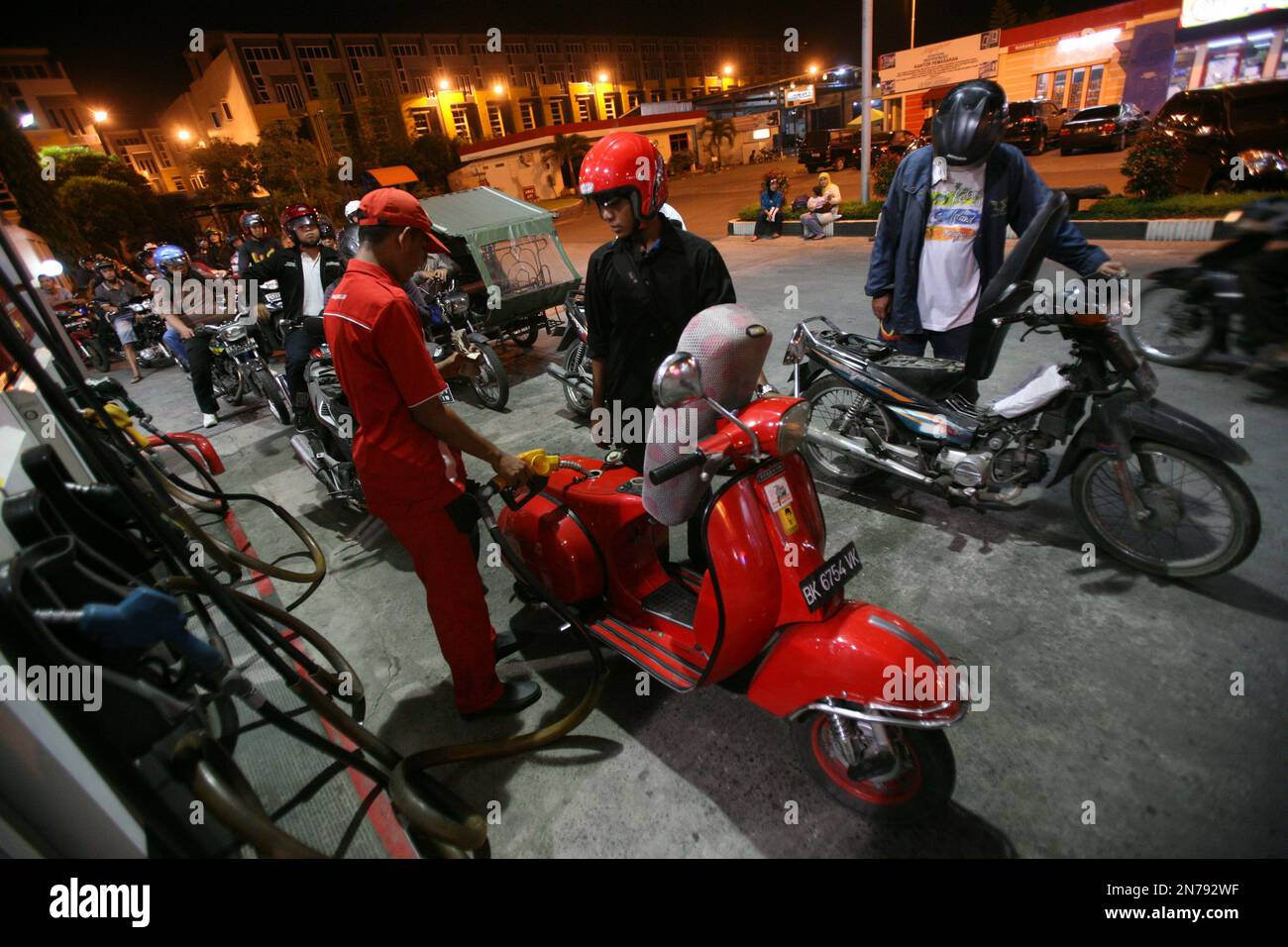 Motorists queue up to fill up their tanks with cheaper gas before the fuel price hike that was ...