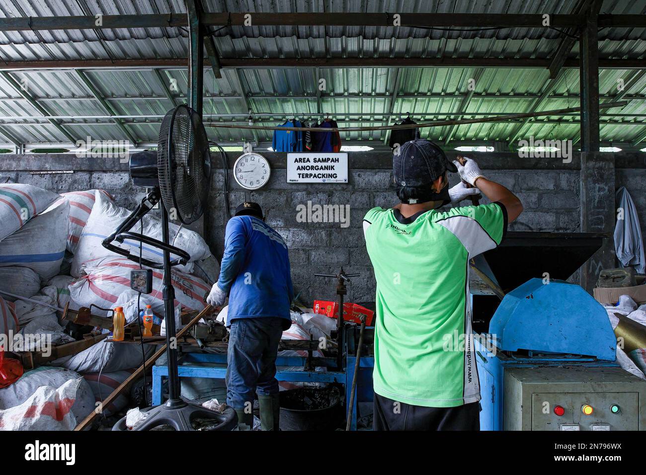 Workers make bricks made from plastic waste at a waste management site ...