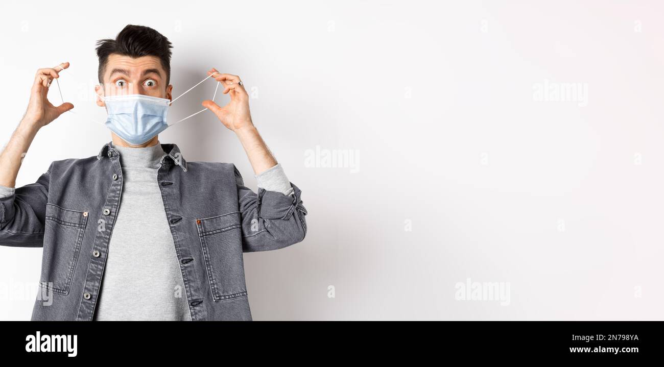 Health, covid and pandemic concept. Funny guy playing with medical mask ...