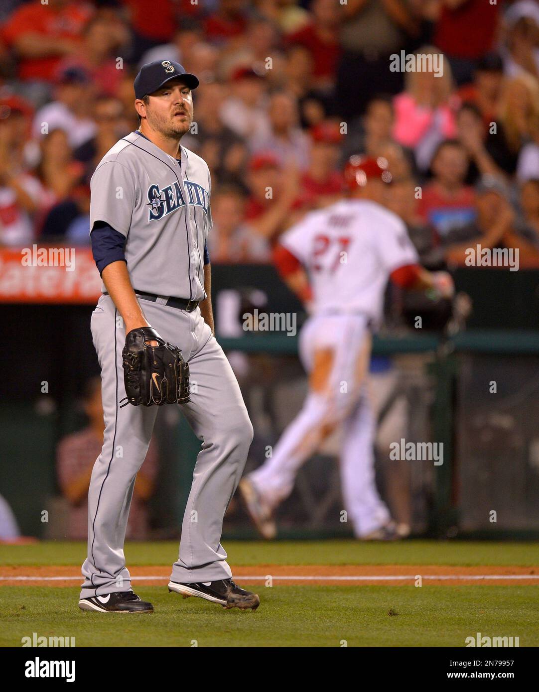 Seattle Mariners starting pitcher Joe Saunders, left, looks on after ...