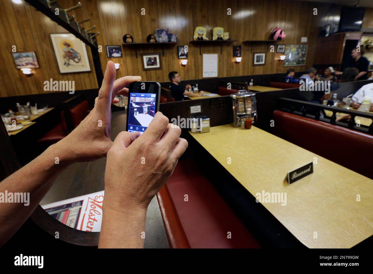 Liz O'Neil, of Montclair, N.J., takes a photograph of a reserved booth ...